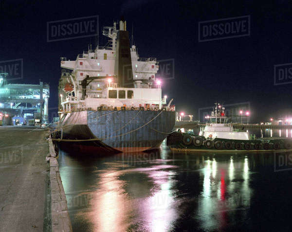 Tugboat and ship moored in harbor - Royalty-free Stock Photo | Dissolve