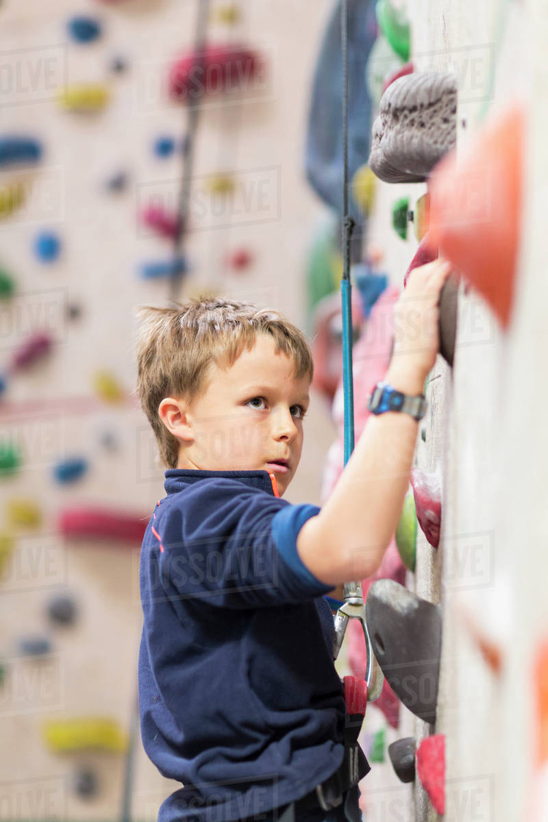 Caucasian boy climbing rock wall indoors - Royalty-free Stock Photo ...