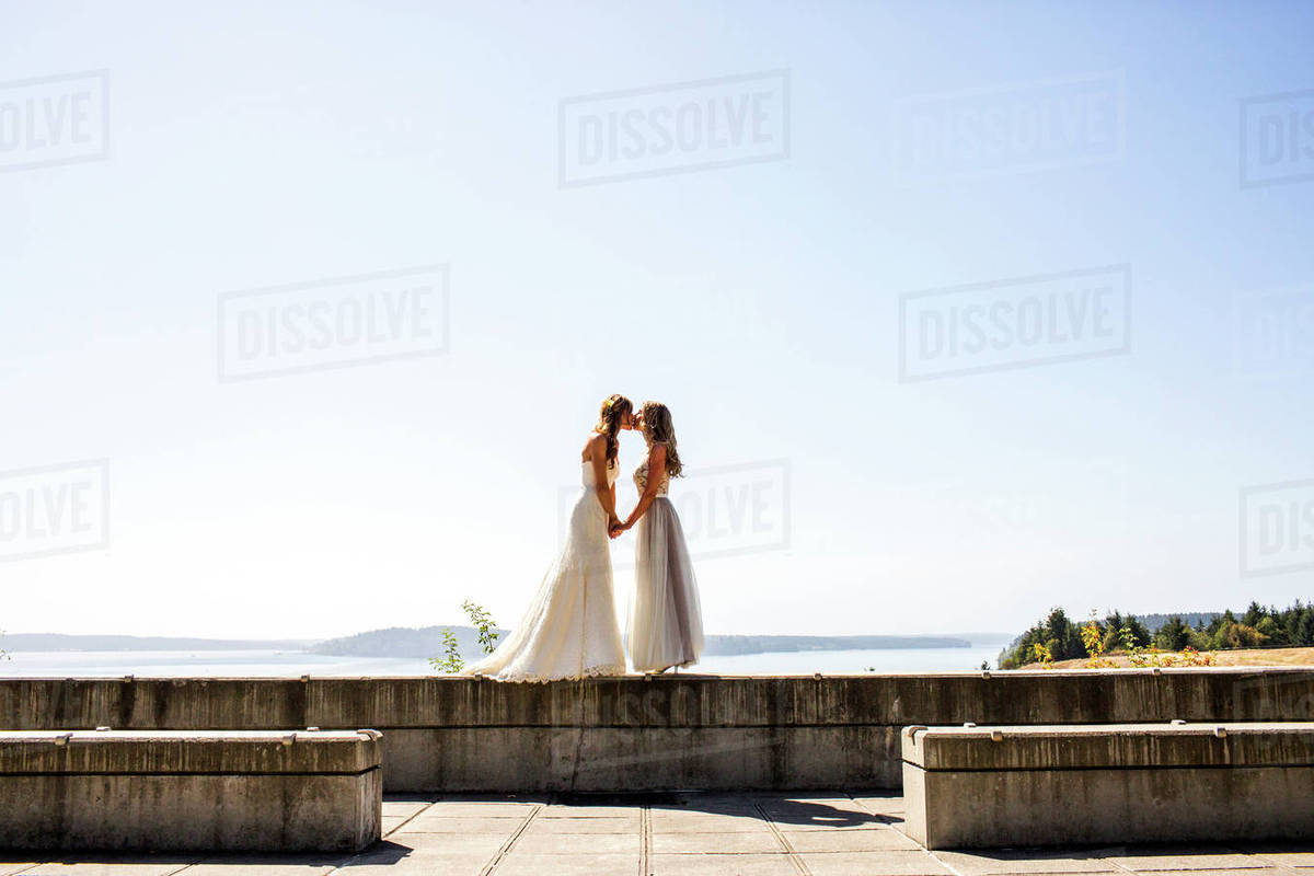 Brides kissing at waterfront - Royalty-free Stock Photo | Dissolve
