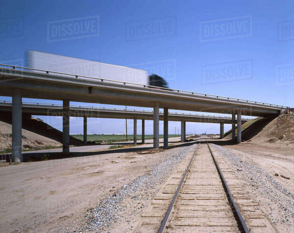 Trucks driving on freeway overpass over train track - Royalty-free ...