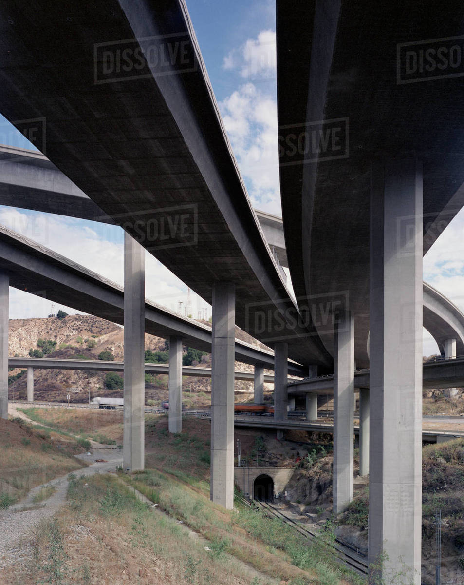 Trucks and cars driving under freeway overpass - Royalty-free Stock ...