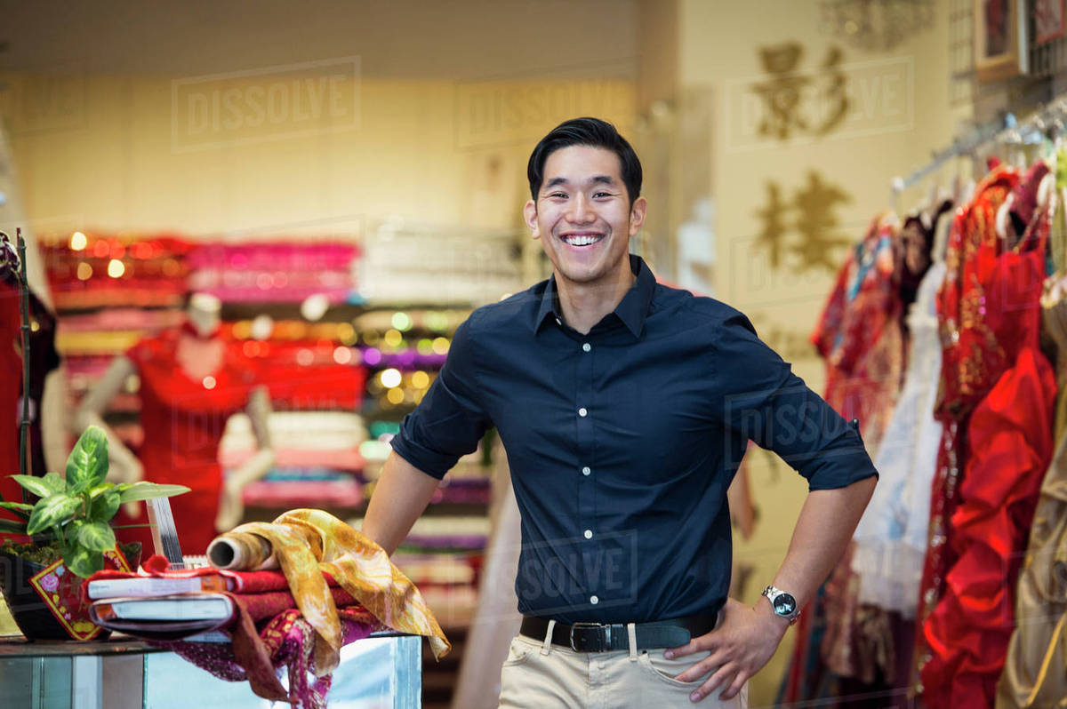 Smiling Chinese man posing in store - Stock Photo - Dissolve
