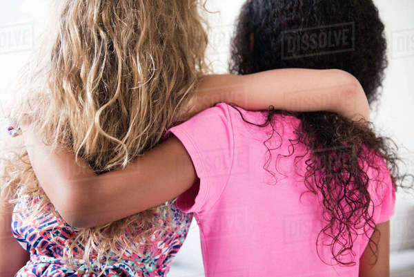 Rear view of girls hugging - Royalty-free Stock Photo | Dissolve