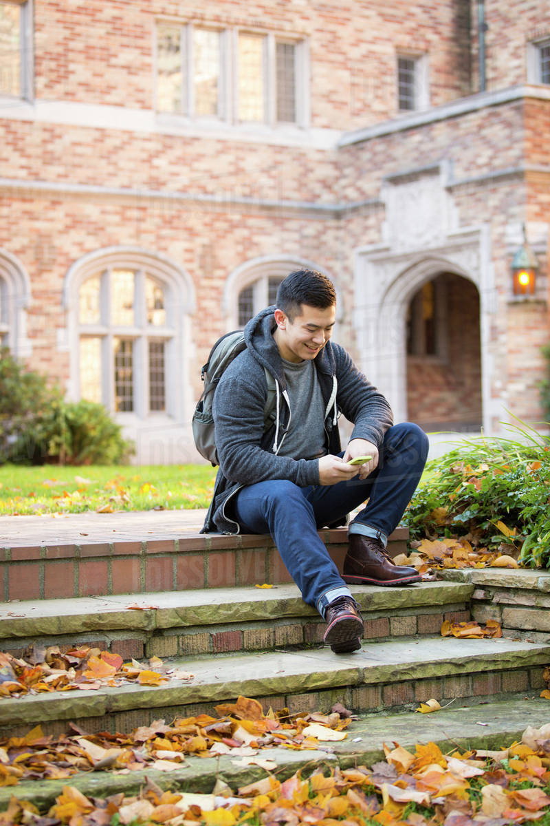Mixed race college student sitting on campus steps - Royalty-free Stock ...