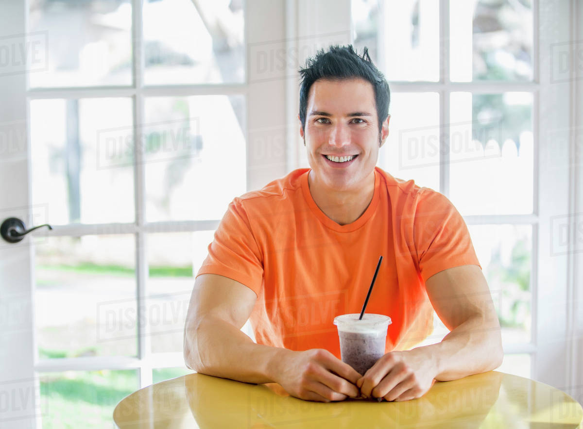 Caucasian man drinking smoothie in kitchen - Royalty-free Stock Photo ...