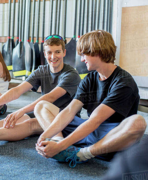 Caucasian boys stretching in boathouse - Stock Photo - Dissolve