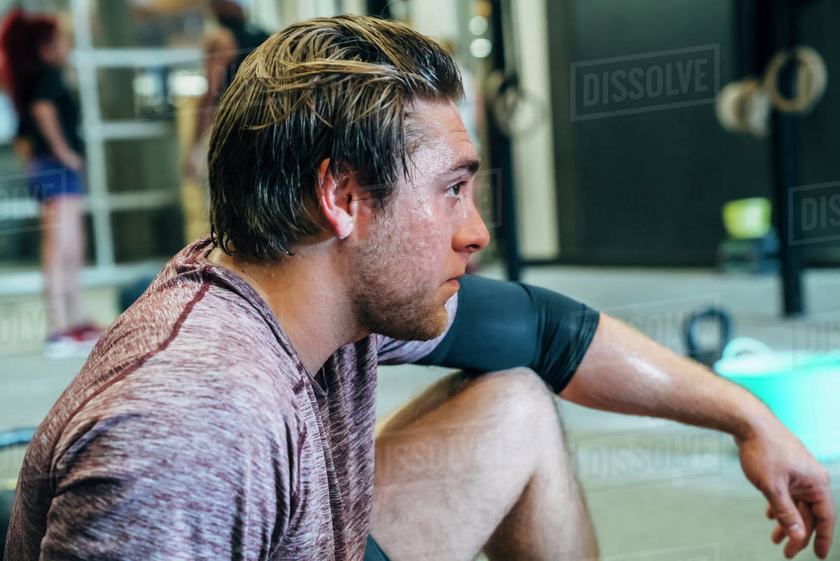Sweating man resting in gymnasium - Stock Photo - Dissolve