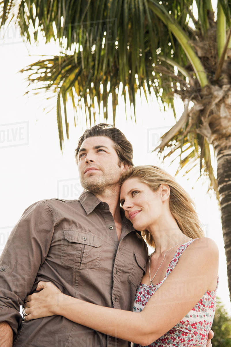 Couple hugging under palm tree - Royalty-free Stock Photo | Dissolve