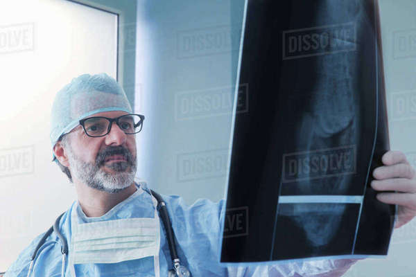 Surgeon examining x-ray - Stock Photo - Dissolve