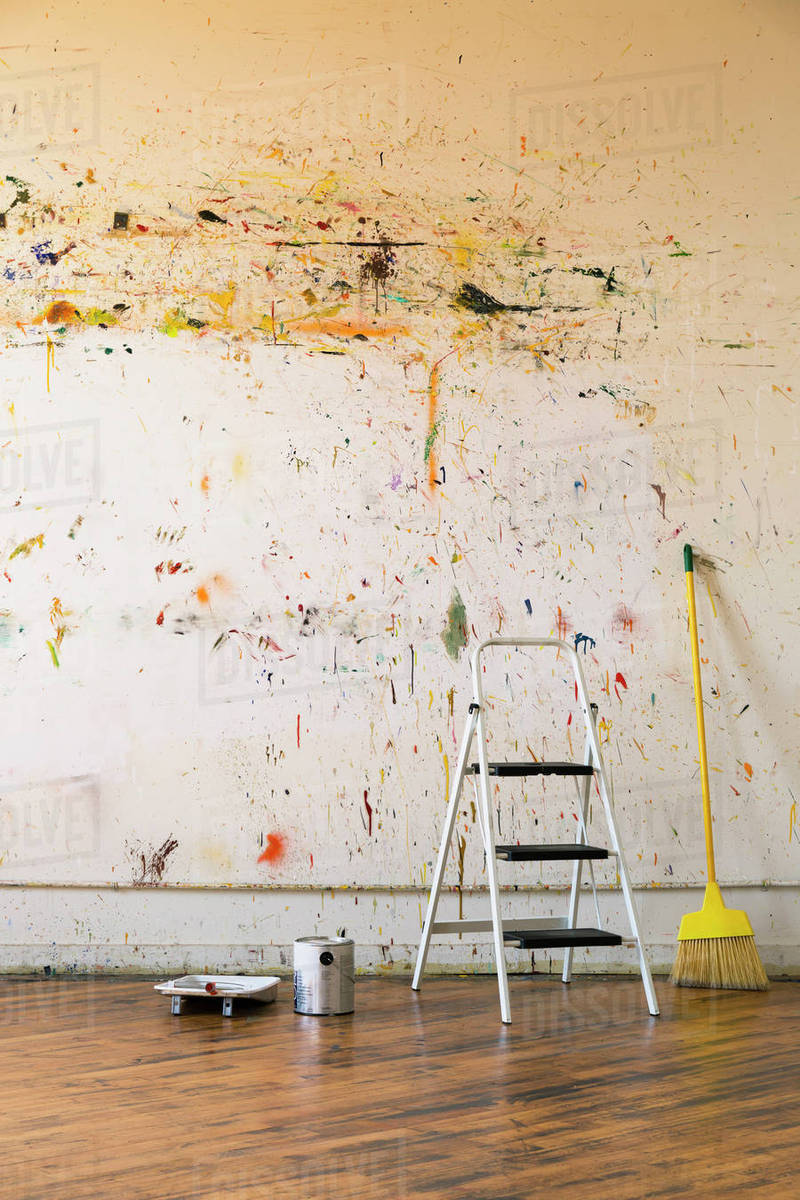 Paint splattered on wall near ladder and broom - Stock Photo - Dissolve