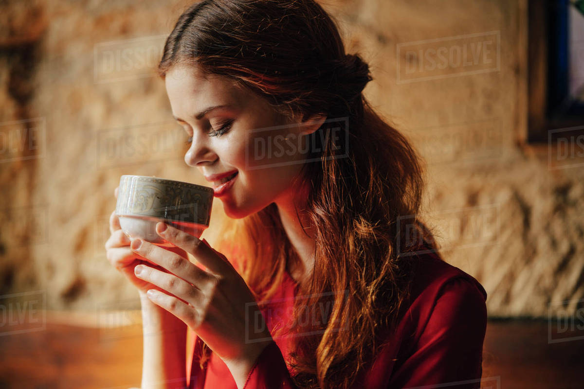 Woman sipping cup of tea - Stock Photo - Dissolve