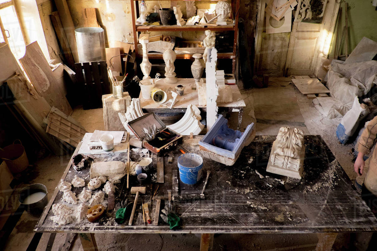 Caucasian artist in messy studio - Stock Photo - Dissolve