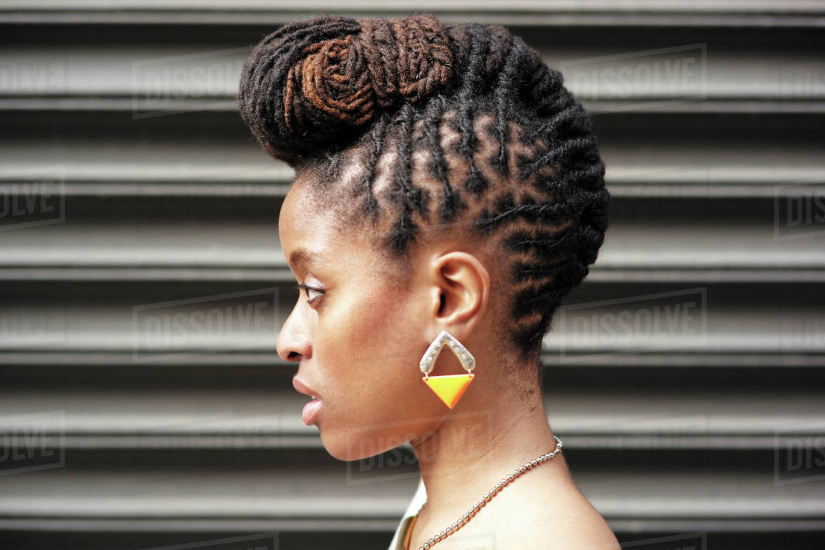 Profile of African American woman with braids near metal wall - Royalty ...