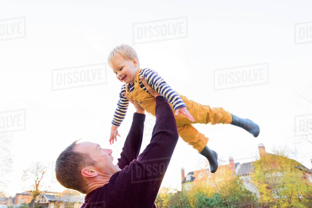 Caucasian father lifting son - Stock Photo - Dissolve
