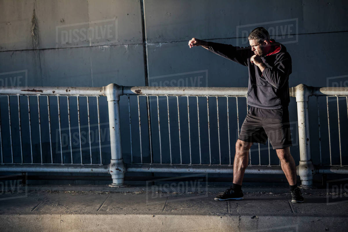 Caucasian man shadow boxing near railing - Royalty-free Stock Photo ...