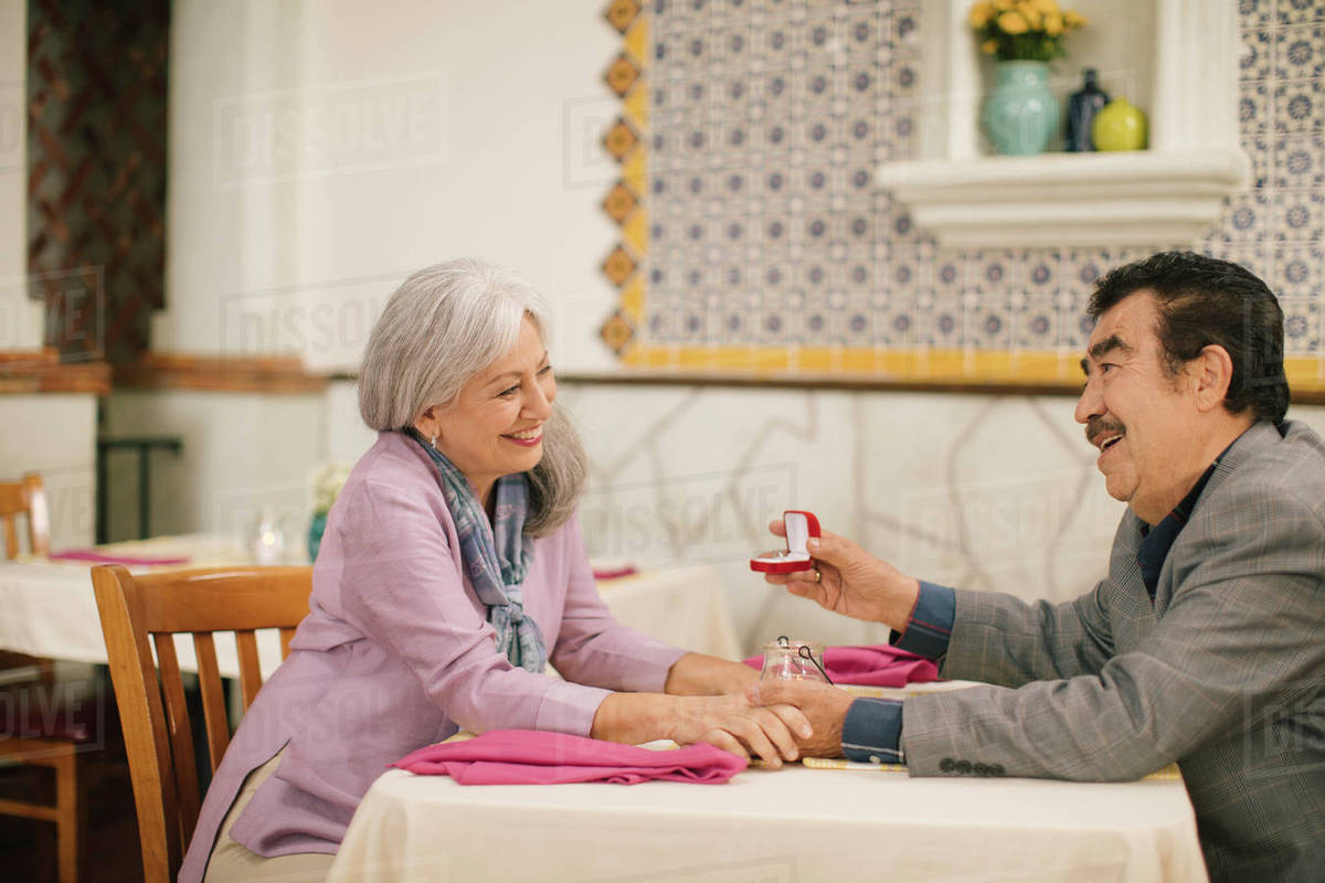 Older man proposing marriage to woman in restaurant - Stock Photo ...