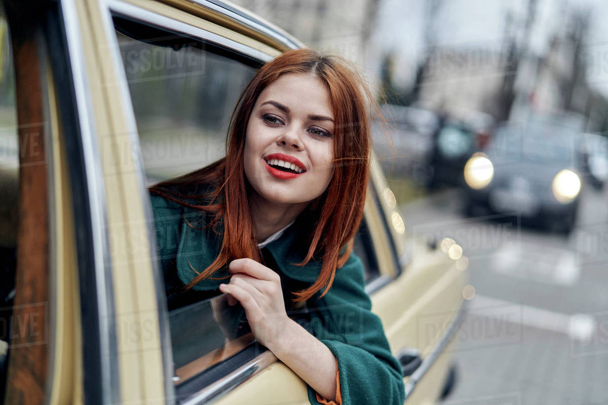 Smiling Caucasian woman in back seat of car - Stock Photo - Dissolve