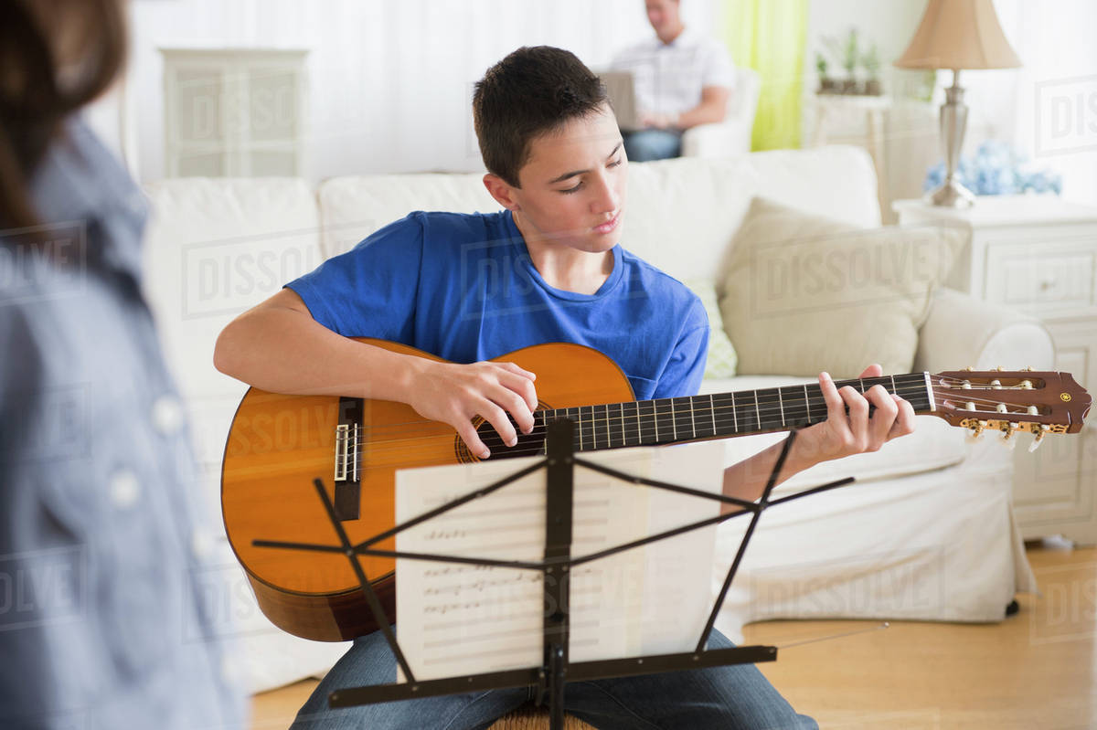 Caucasian boy practicing guitar in living room - Royalty-free Stock ...