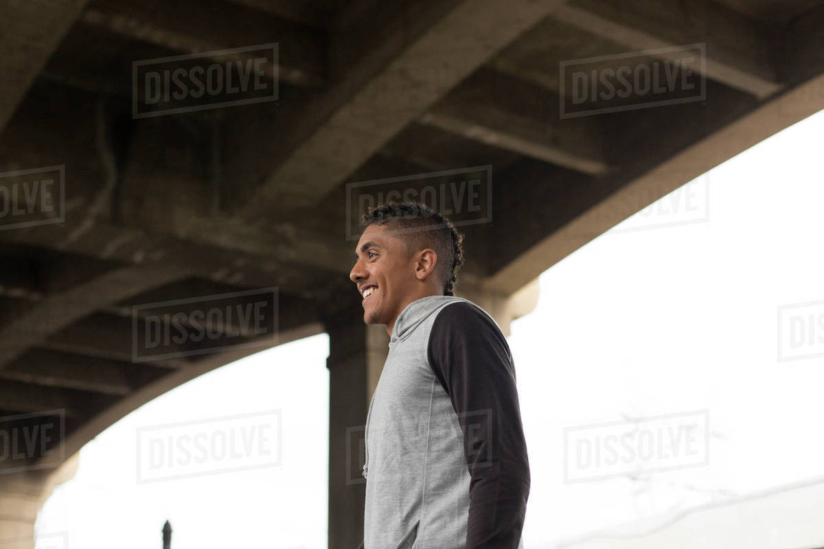 Smiling Mixed Race man standing under bridge - Royalty-free Stock Photo ...