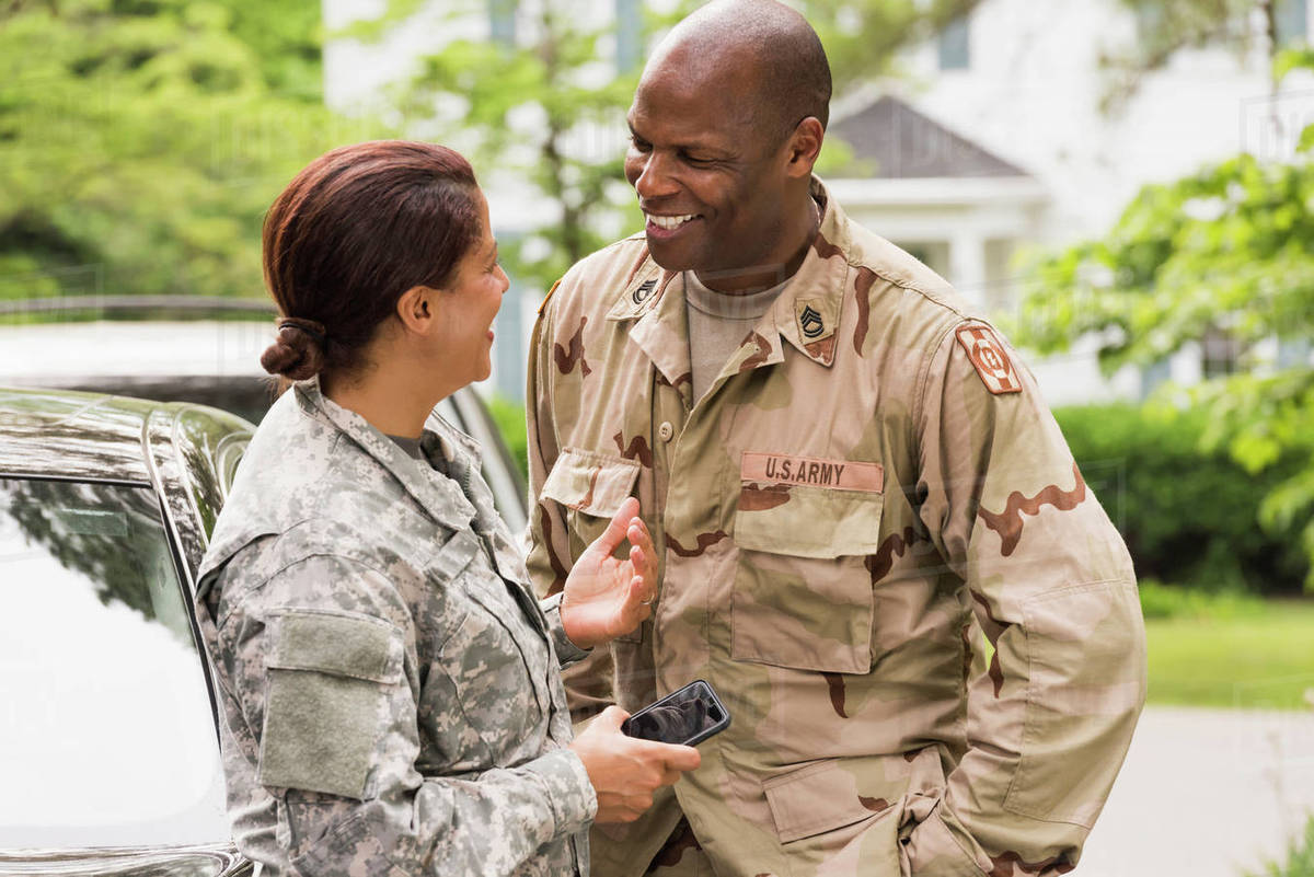 Smiling African American soldier couple talking near car - Royalty-free ...