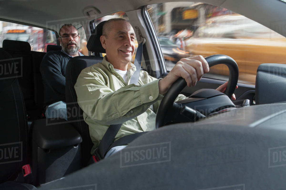Smiling Hispanic man driving car with passenger - Royalty-free Stock ...