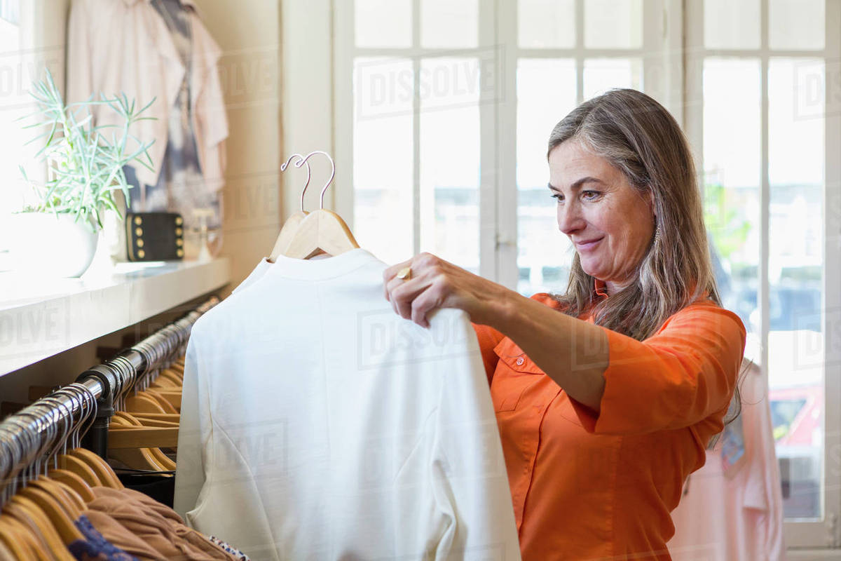 Caucasian woman shopping at clothing store - Stock Photo - Dissolve