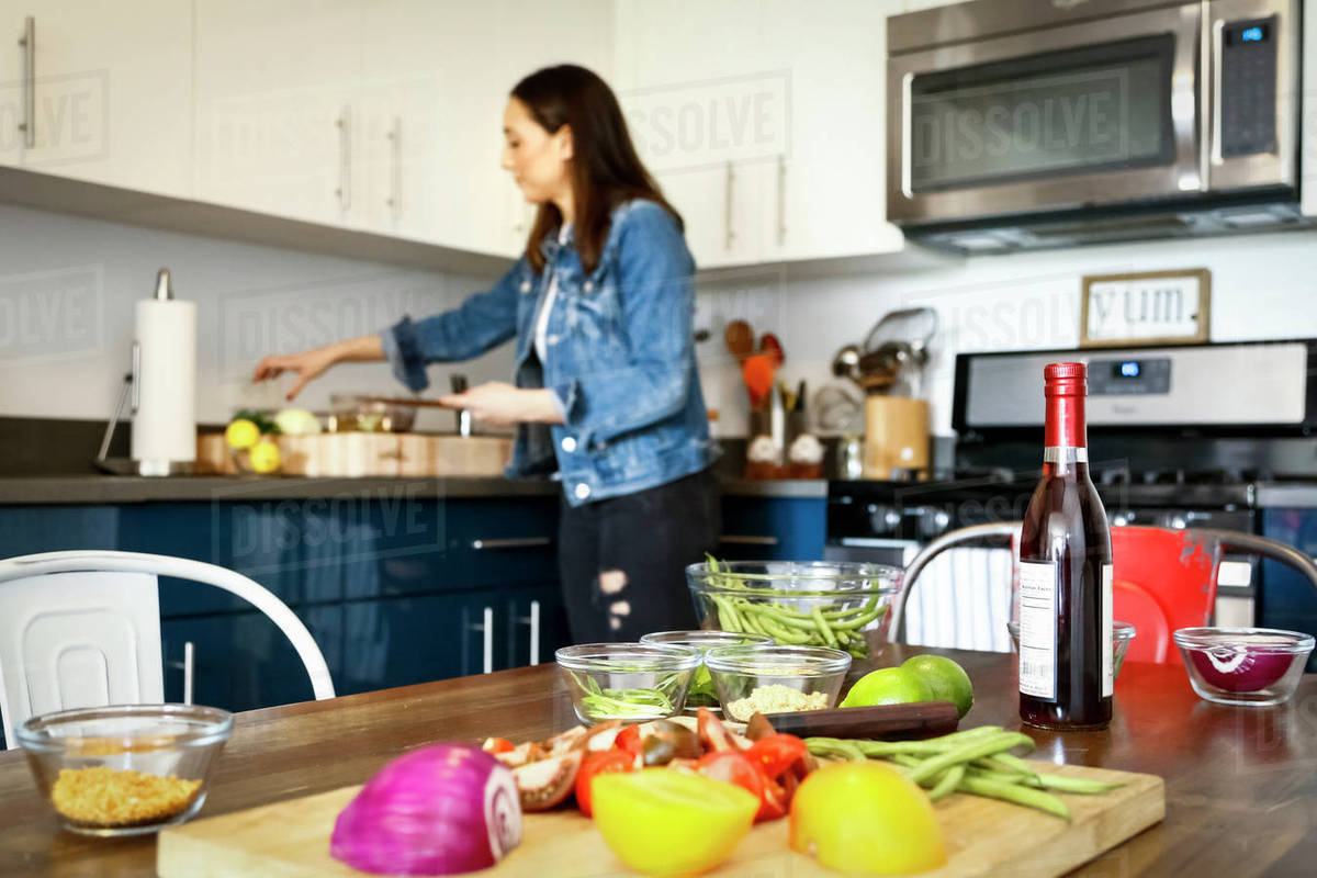 Woman chopping vegetables in kitchen - Stock Photo - Dissolve