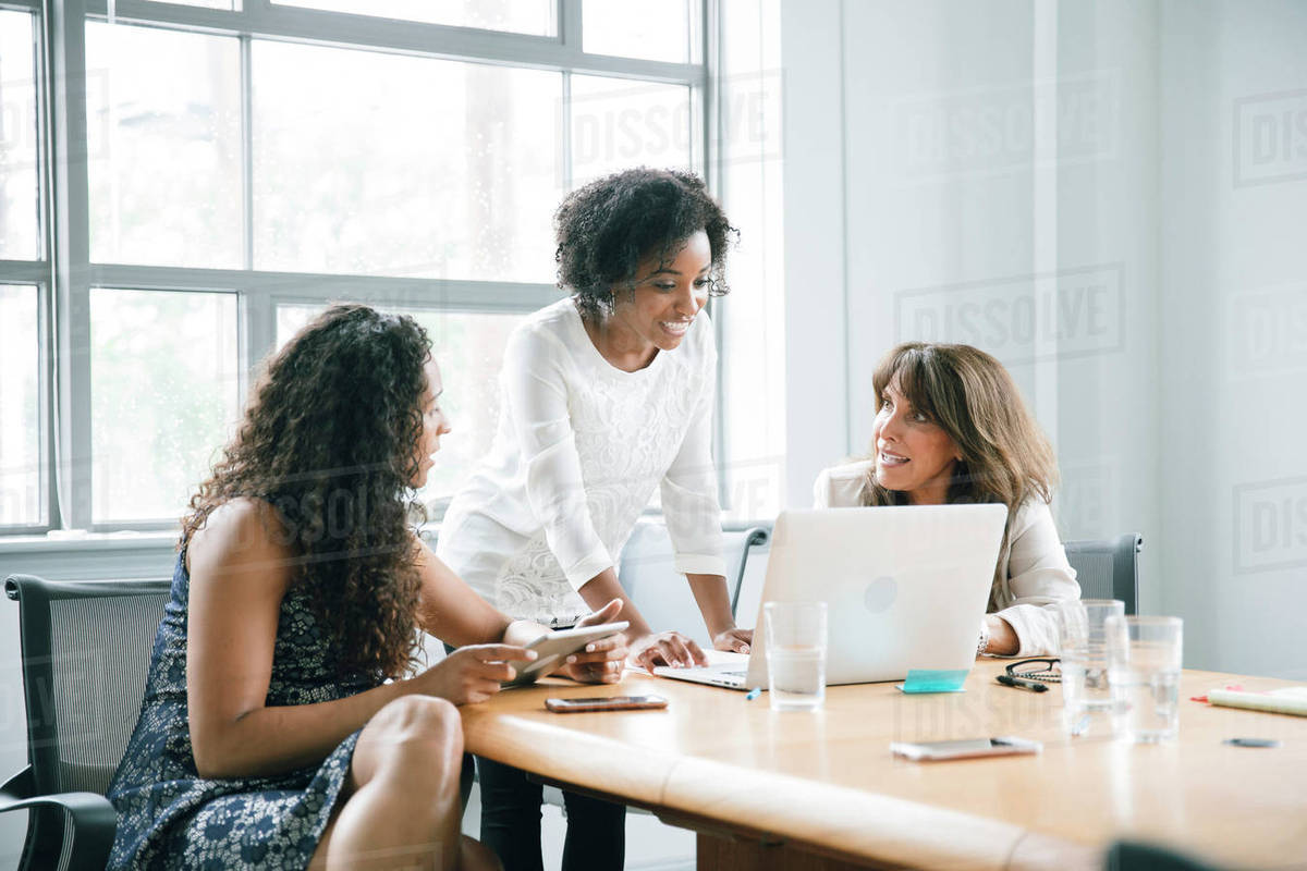 Businesswomen using laptop in meeting - Royalty-free Stock Photo | Dissolve