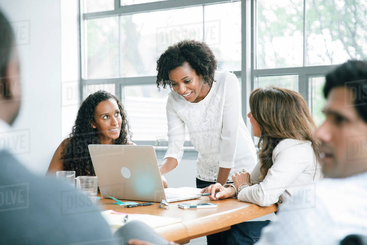 Businesswomen using laptop in meeting - Stock Photo - Dissolve