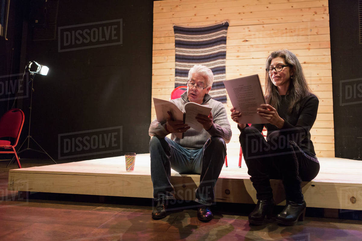 Hispanic man and woman reading scripts on theater stage - Royalty-free ...