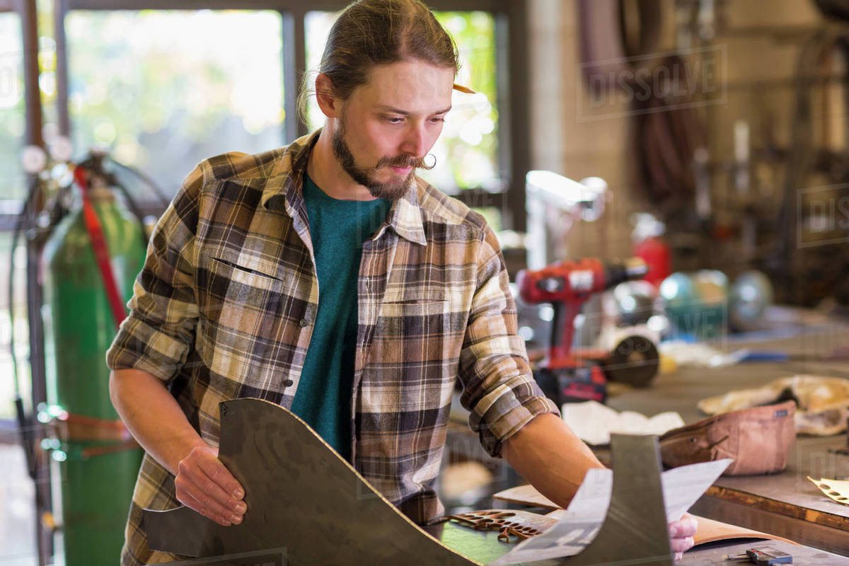 Caucasian man holding metal and reading paperwork - Royalty-free Stock ...