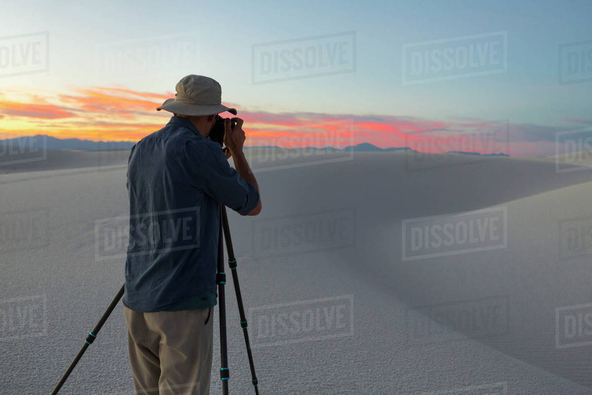 Caucasian man photographing desert at sunset - Royalty-free Stock Photo ...