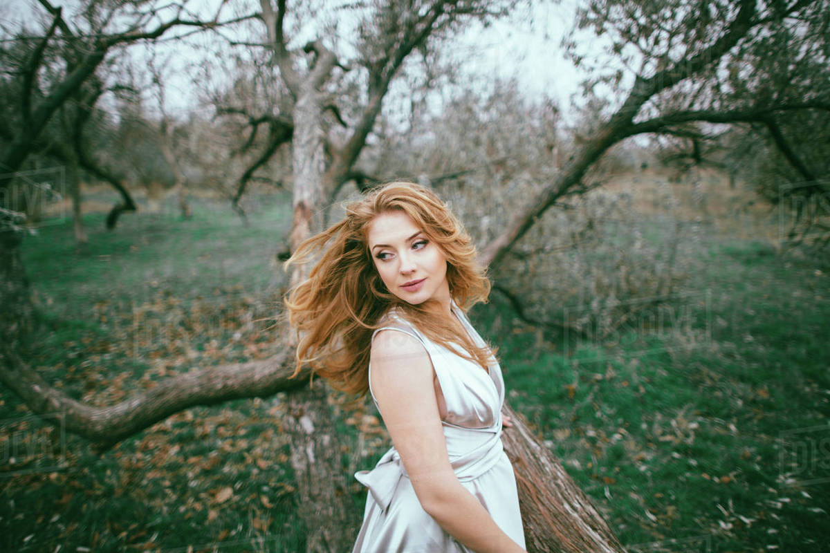Glamorous Caucasian woman tossing hair near tree - Royalty-free Stock ...