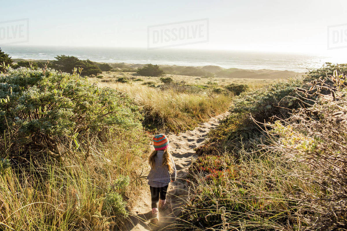 Caucasian girl walking on sandy path - Royalty-free Stock Photo | Dissolve