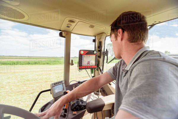 Caucasian man driving tractor on farm - Stock Photo - Dissolve