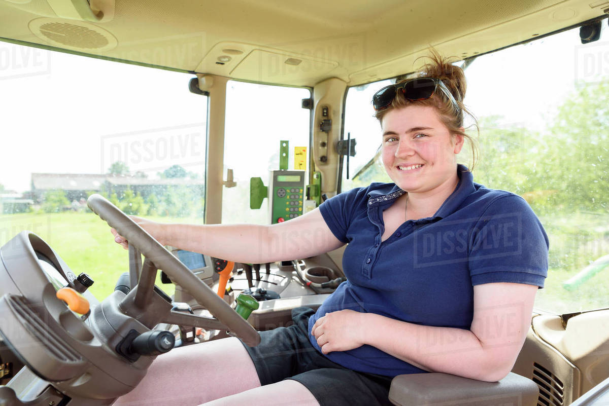 Portrait of smiling Caucasian woman driving tractor - Stock Photo ...