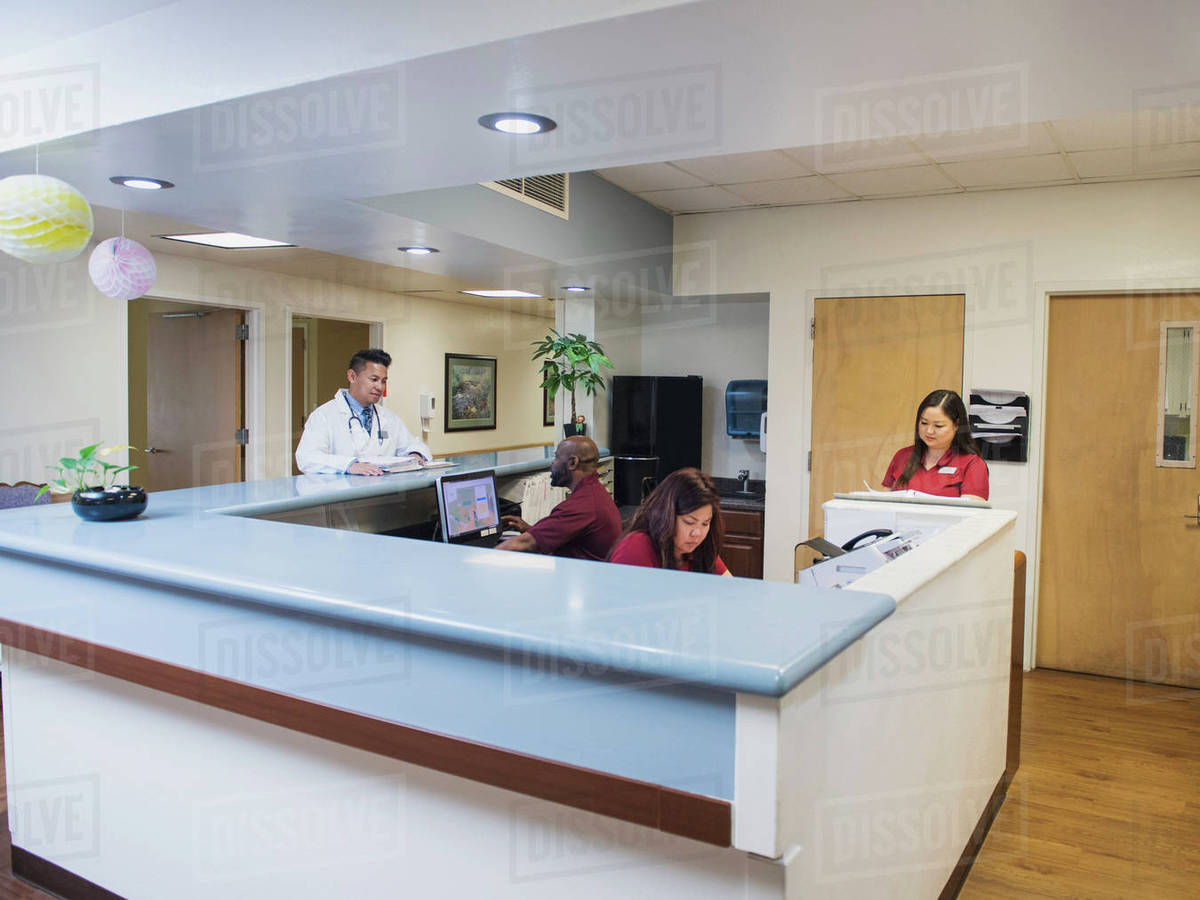 Doctor and nurses at counter in hospital - Royalty-free Stock Photo ...