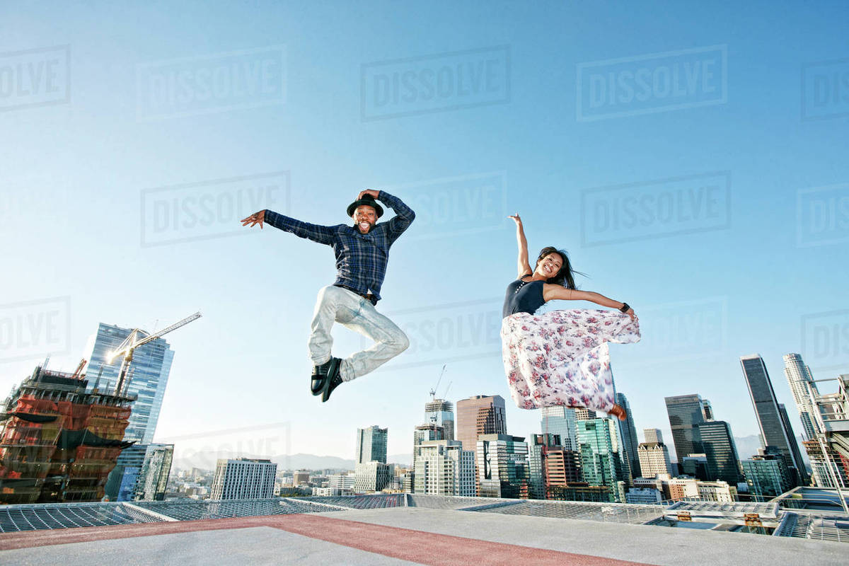 Couple dancing and jumping on urban rooftop - Royalty-free Stock Photo ...
