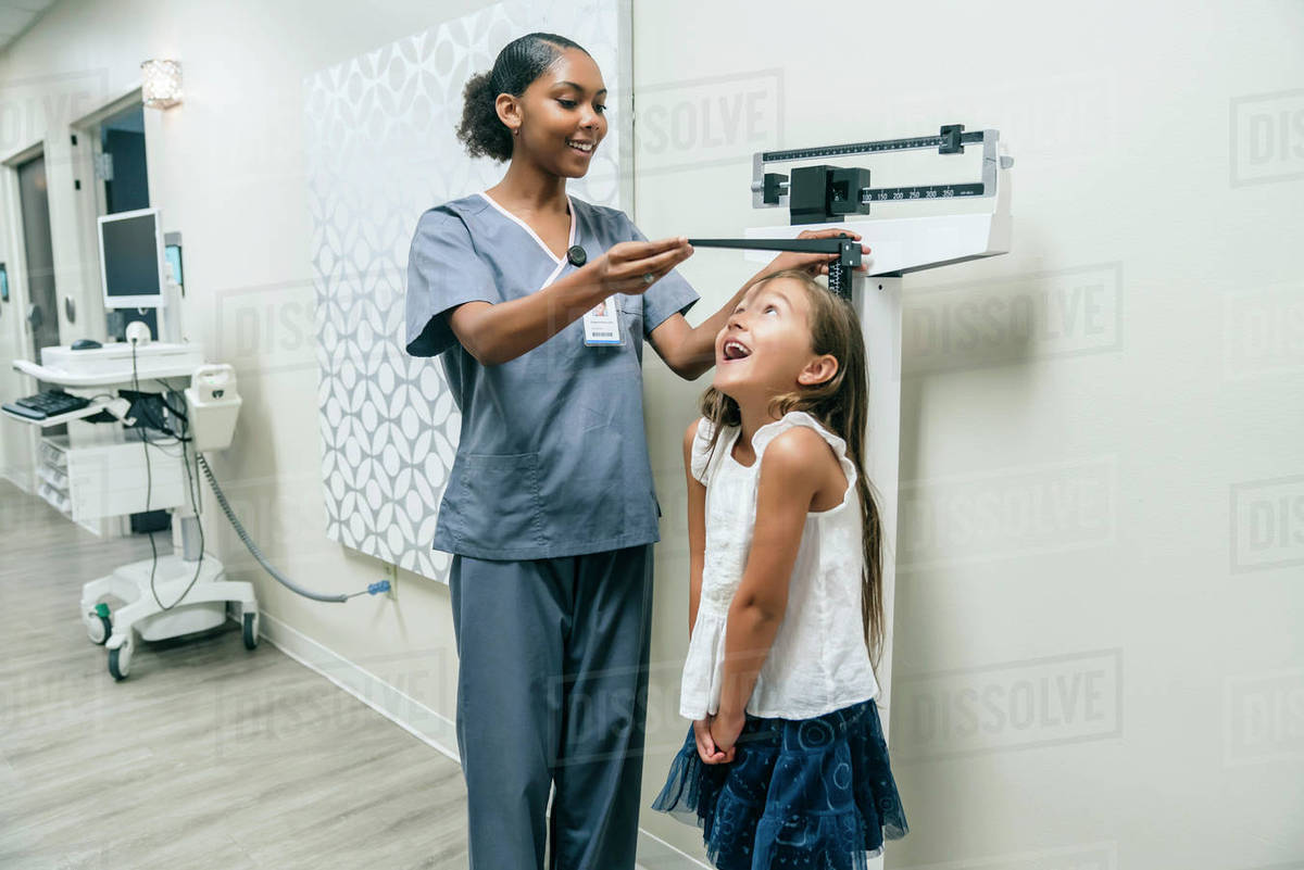Nurse measuring height of girl - Royalty-free Stock Photo | Dissolve