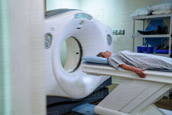 Caucasian patient laying on scanner table - Stock Photo - Dissolve