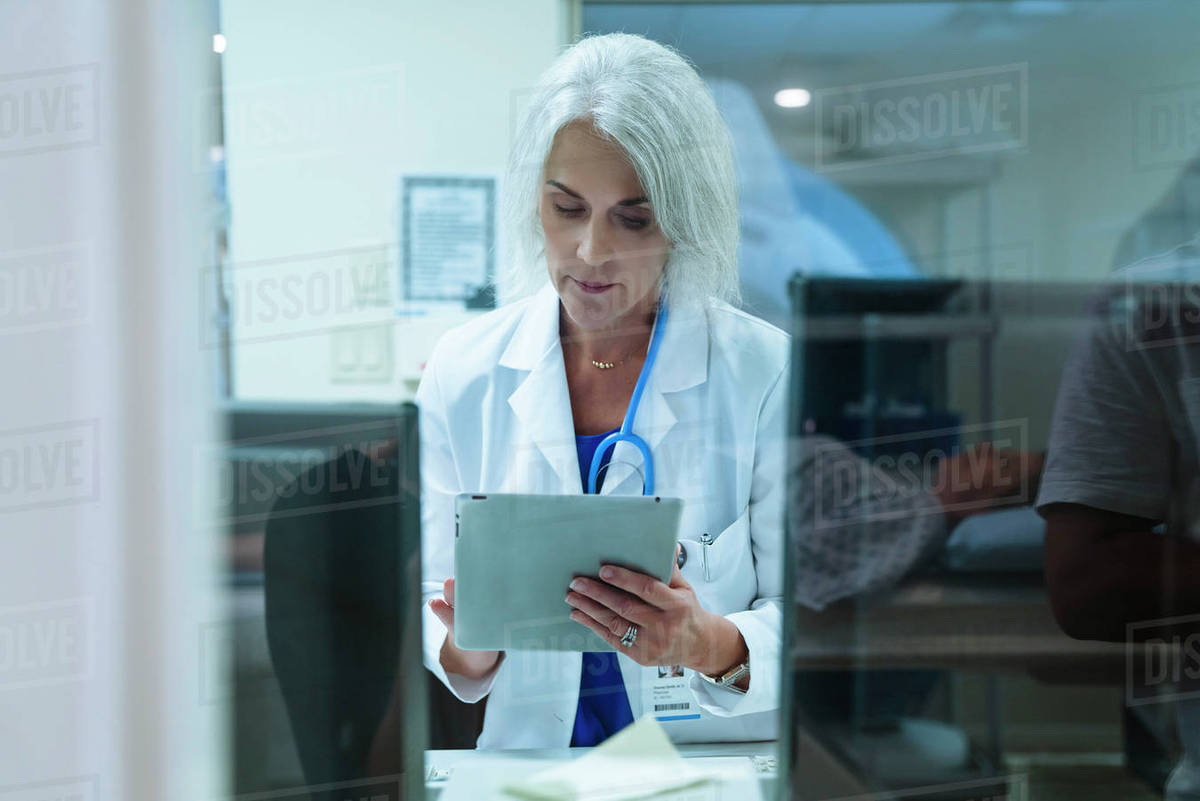 Doctor using digital tablet - Stock Photo - Dissolve