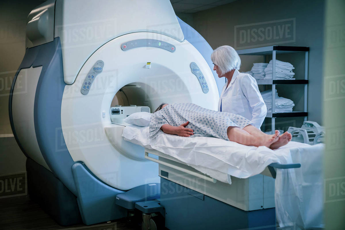 Doctor talking to patient at scanner - Royalty-free Stock Photo | Dissolve