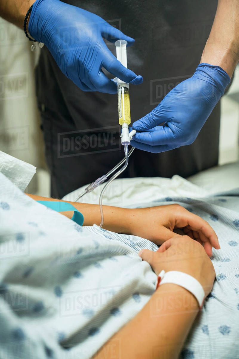 Nurse injecting medicine into tube of patient - Royalty-free Stock ...
