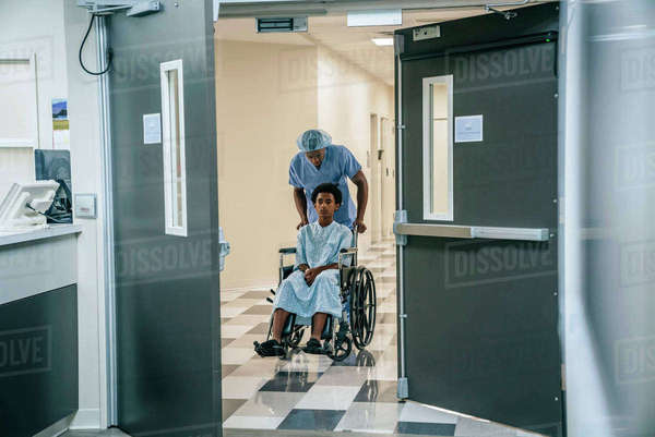Black nurse pushing boy in wheelchair - Royalty-free Stock Photo | Dissolve