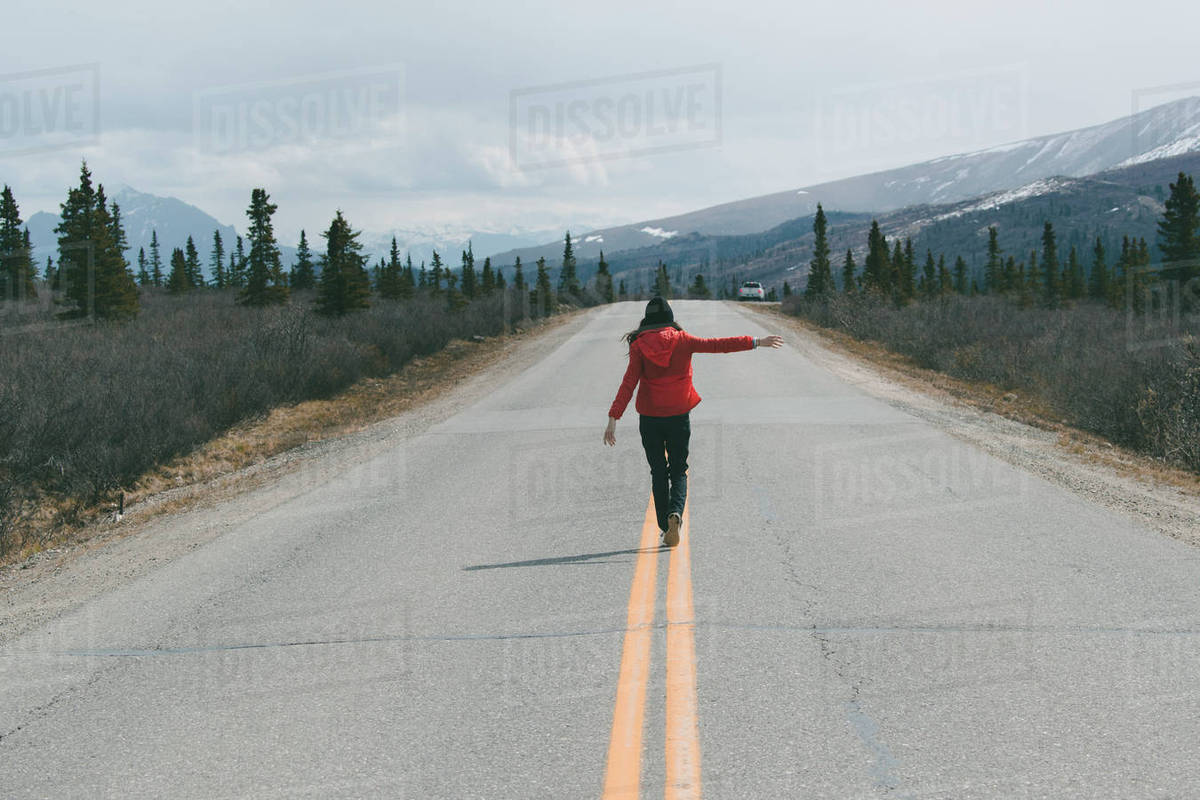 Caucasian woman balancing on stripes in two-lane road - Stock Photo ...