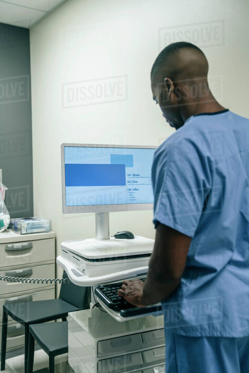 Black doctor using computer in hospital - Royalty-free Stock Photo ...