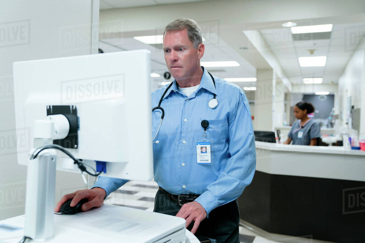 Doctor using computer in hospital - Stock Photo - Dissolve