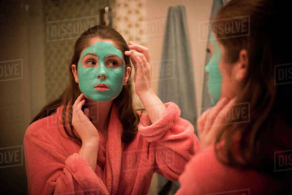 Caucasian girl applying facial mask in mirror - Royalty-free Stock ...
