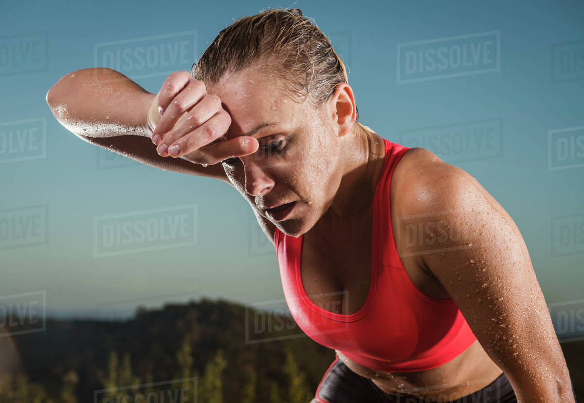 Caucasian woman wiping sweat from forehead - Royalty-free Stock Photo ...