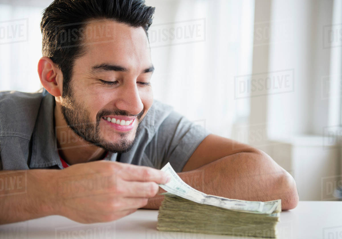 Mixed race man counting stack of money - Royalty-free Stock Photo ...